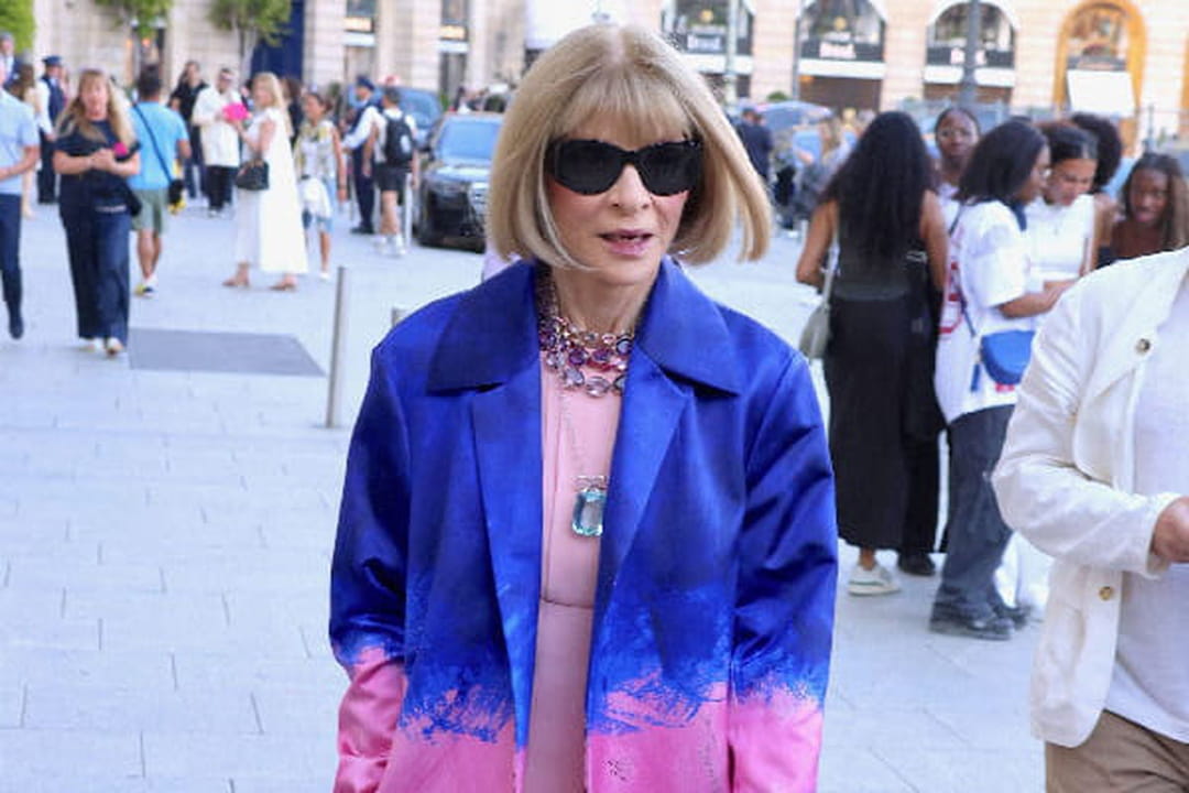 Anna Wintour en manteau rose et bleu et robe rose pâle