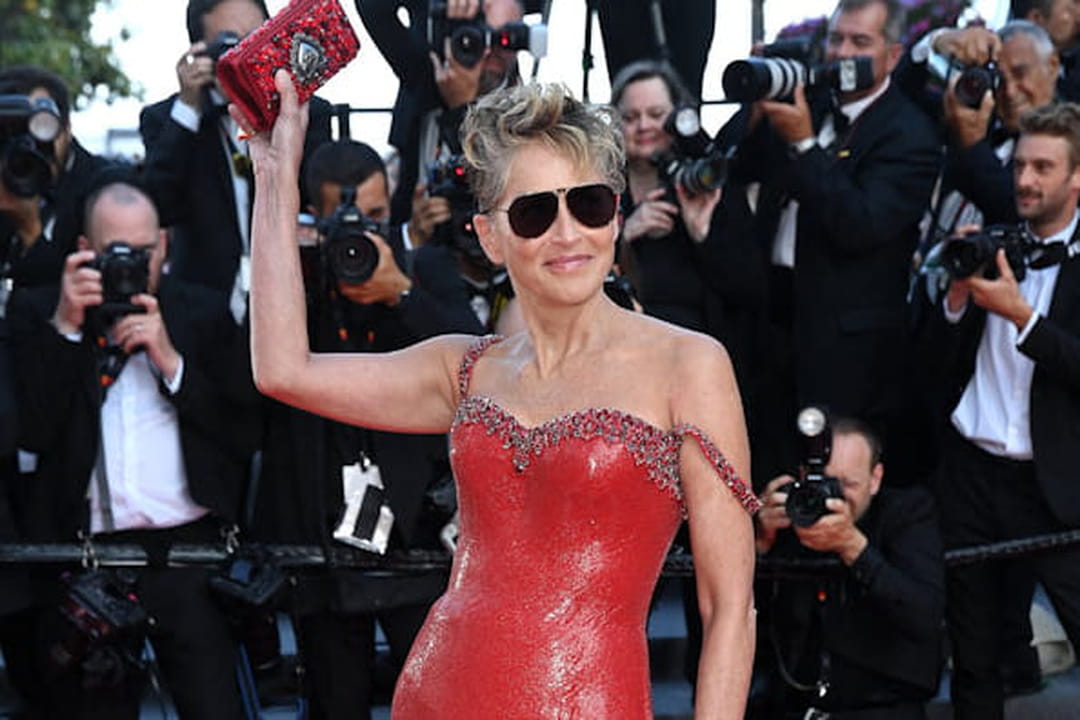 Sharon Stone dans une robe rouge moulante avec des lunettes de soleil ...