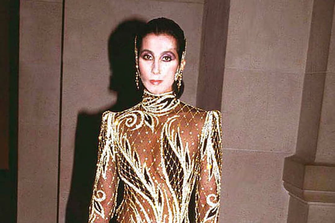 Cher en top brodé de strass dorés et jupe noire