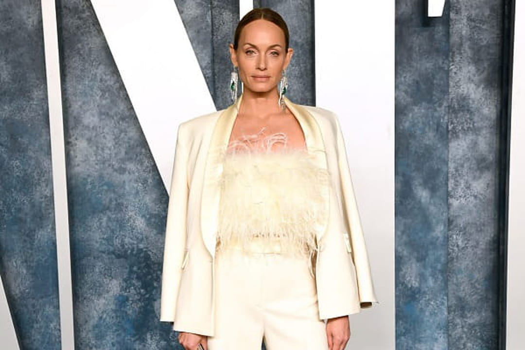 Amber Valletta en smoking écru et top bustier en plumes Mango