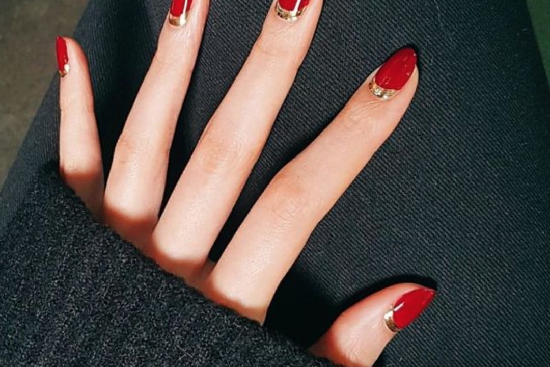 Des ongles rouges avec une touche dorée