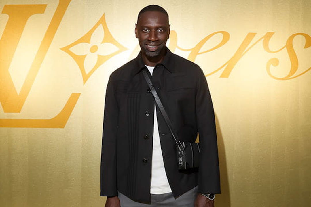 Omar Sy en veste noire et pantalon de costume gris