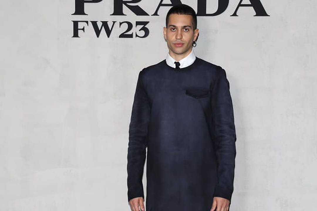 Mahmood en tunique bleu marine et bottes noires au défilé Prada