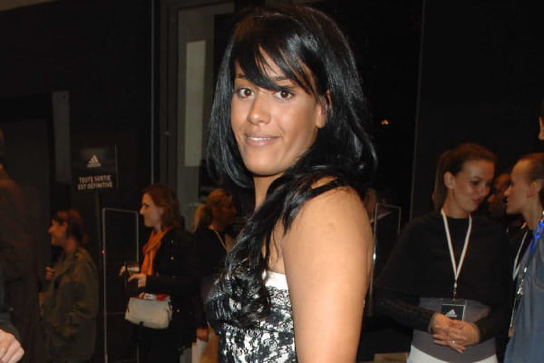 Amel Bent en robe mi-longue noir et blanc en dentelle et pochette noire