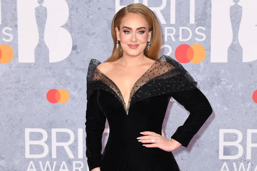 Adele en robe noire décolletée et longue