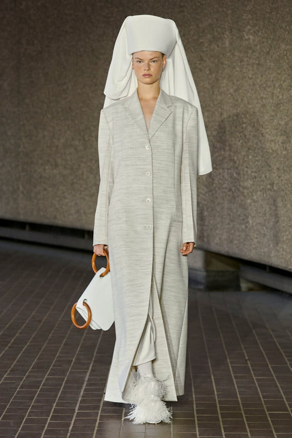 Coiffe blanche, manteau gris clair et chaussures poilues aperçus sur le ...