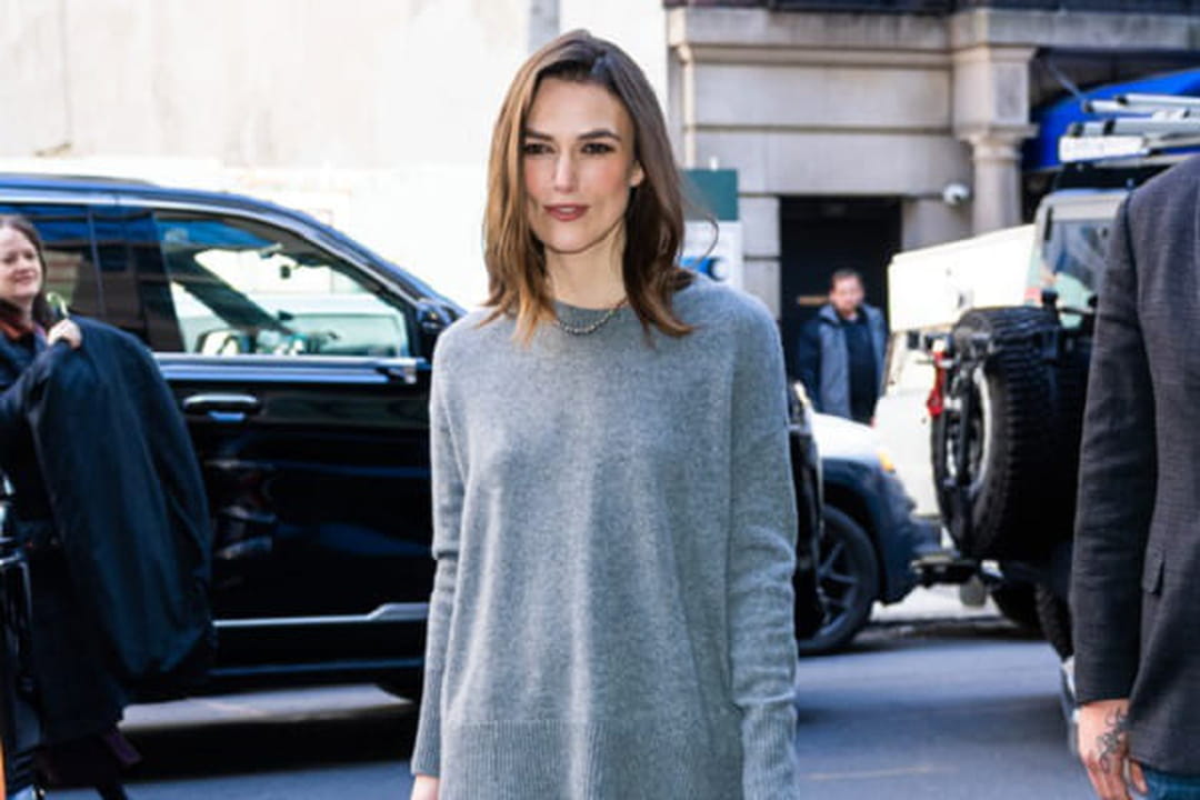 Keira Knightley en pull long gris et jupe à plumes Valentino