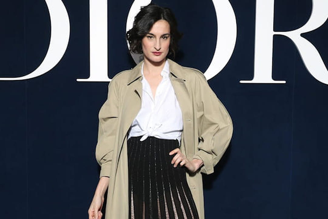 Nine d'Urso en trench et jupe mi-longue transparente à plis au défilé Dior