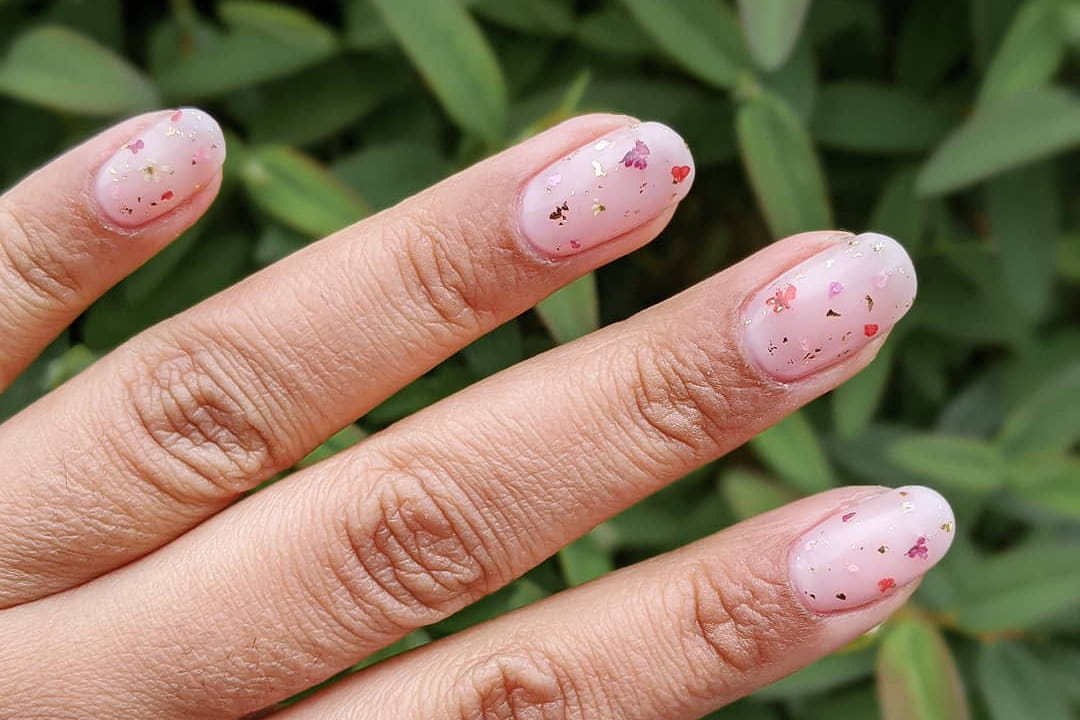 Une manucure à fleurs et paillettes discrètes