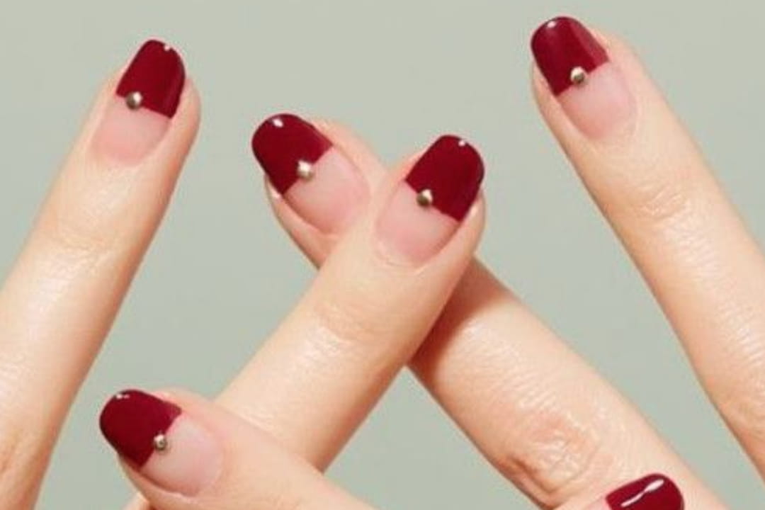 Des ongles rouges à moitié vernis
