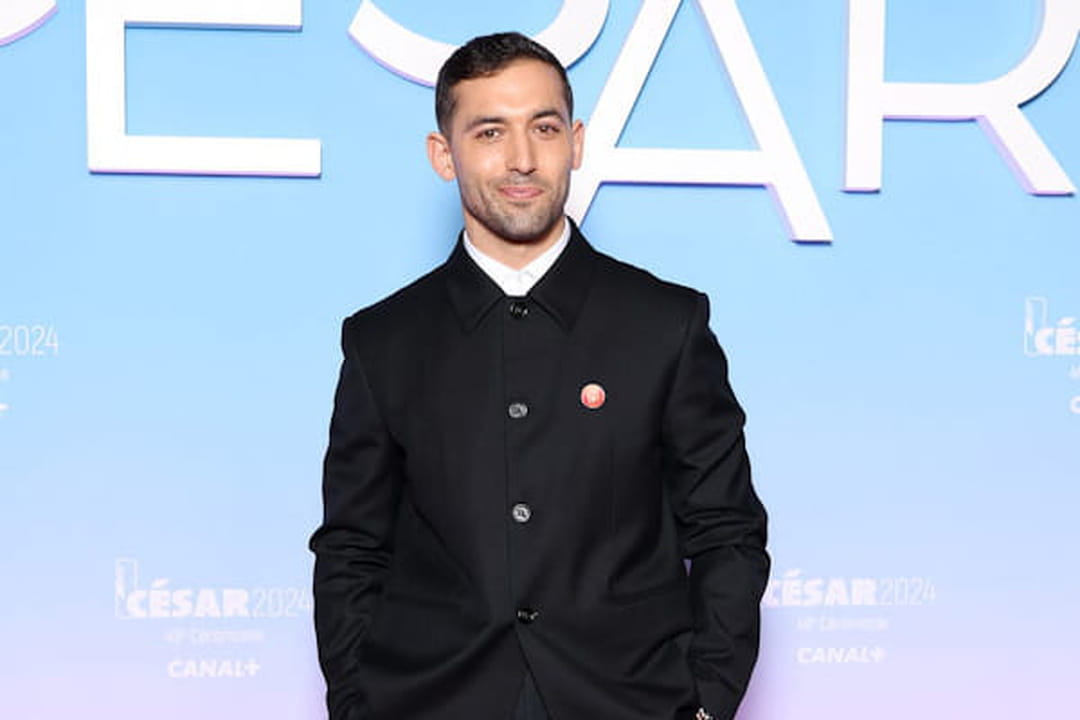 Dali Benssalah en costume noir et chemise blanche Burberry