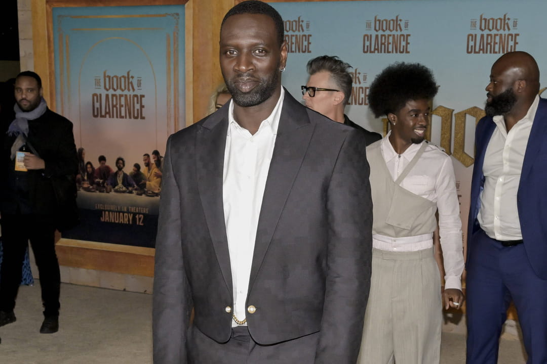 Omar Sy en costume gris et chemise blanche