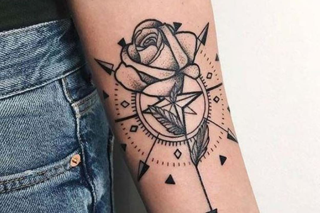 Flèche, rose et boussole sur l'avant-bras