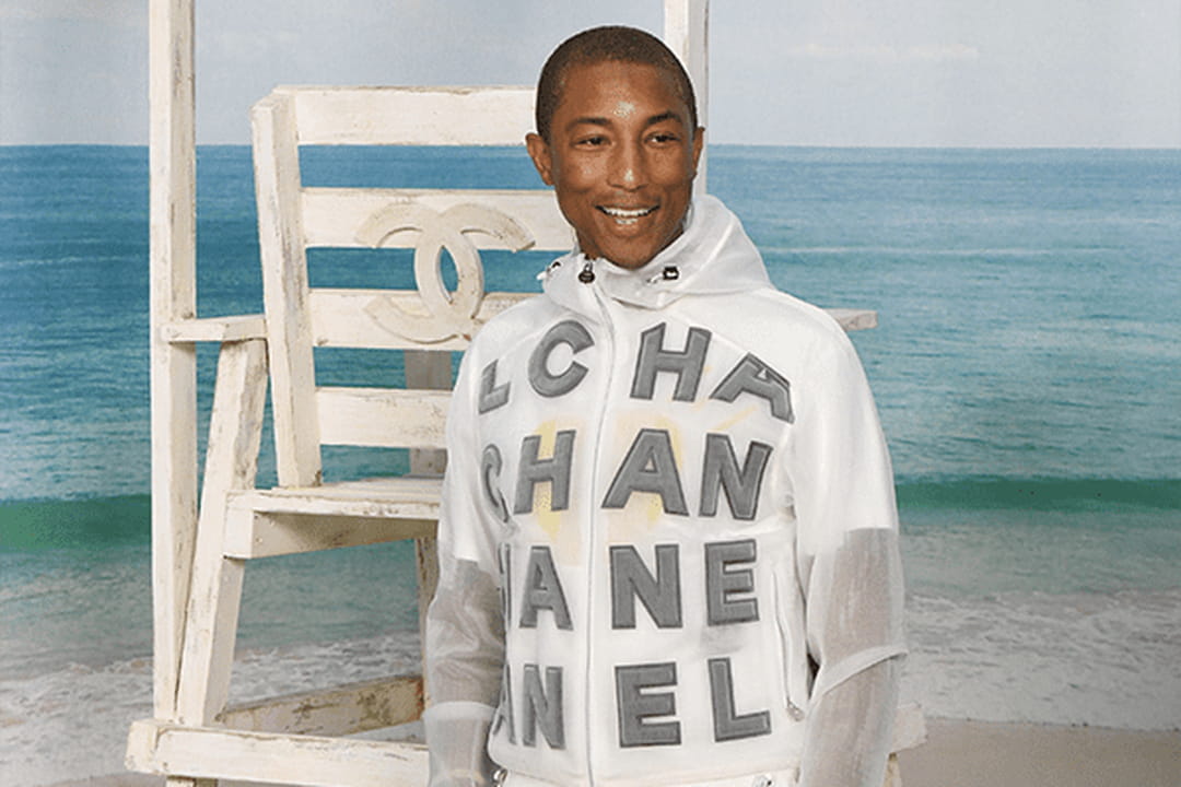 Pharrell Williams en imperméable transparent et baskets Adidas
