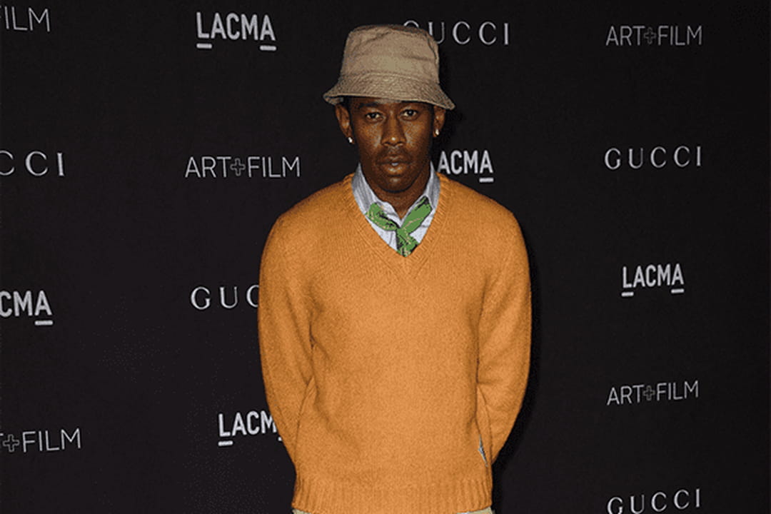 Tyler, The Creator en polo orange manches longues et babies Dr. Martens